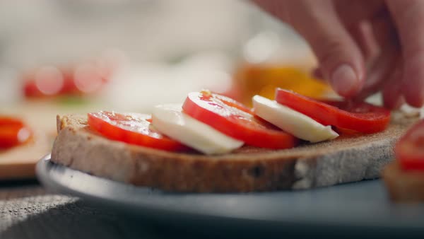 Fried bread, a white race girl diligently lays out slices of tomato and ...