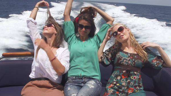 Beautiful young women friends enjoy boat ride in the open sea - Stock ...