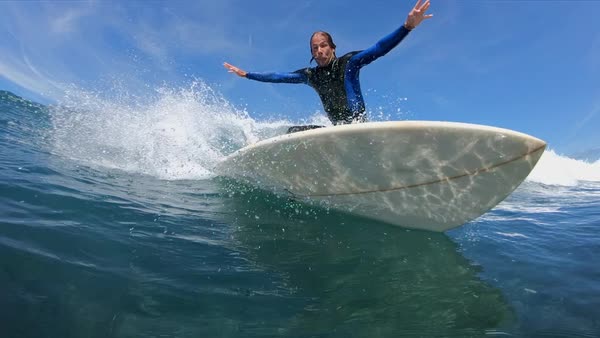 SLOW MOTION, LOW ANGLE: Surfer guy makes a sharp turn on his surfboard ...