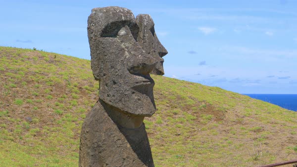 DRONE: Breathtaking shot of ancient moai sculptures set on a grassy ...