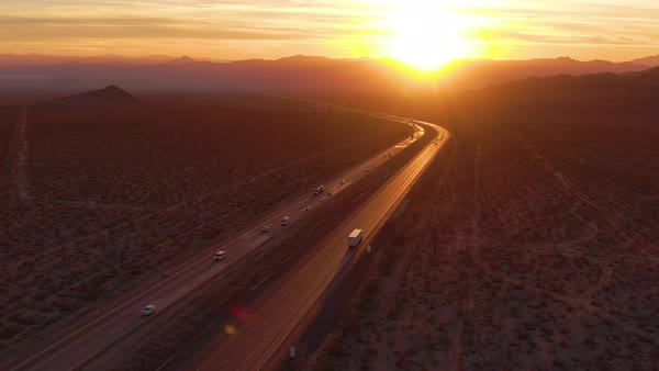 DRONE, LENS FLARE: Flying behind a freight truck driving along the ...
