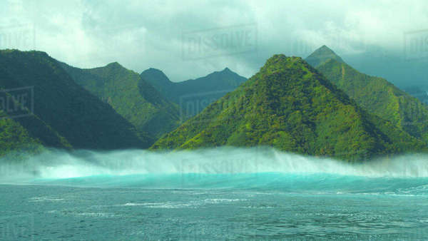 Big dangerous ocean wave surging towards a small tropical island in the ...
