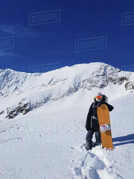 Extreme female snowboarder poses with her cool board before riding down ...