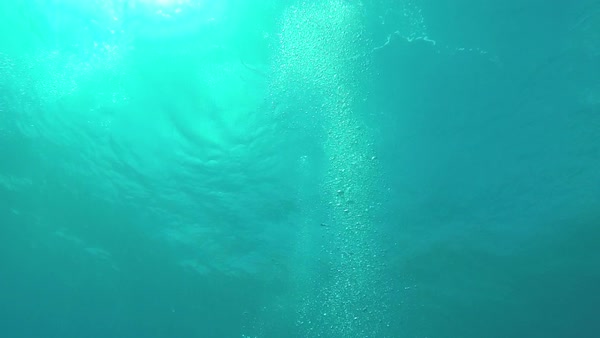 Underwater macro: Numerous small air bubbles rising up to the smooth ...