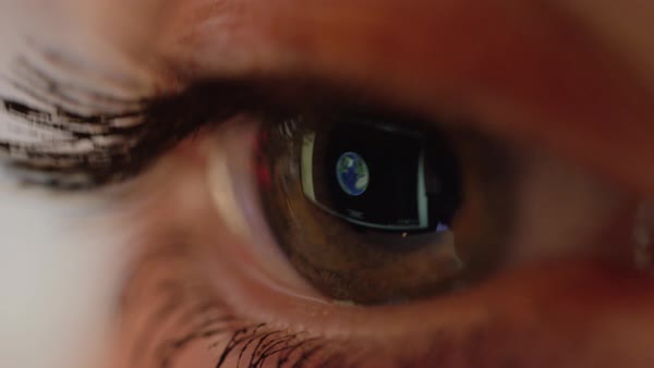 MACRO CLOSEUP Blinking eye looking at world map. Computer screen image ...