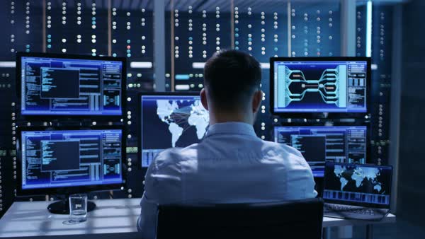 Technical controller working at his workstation with multiple displays ...