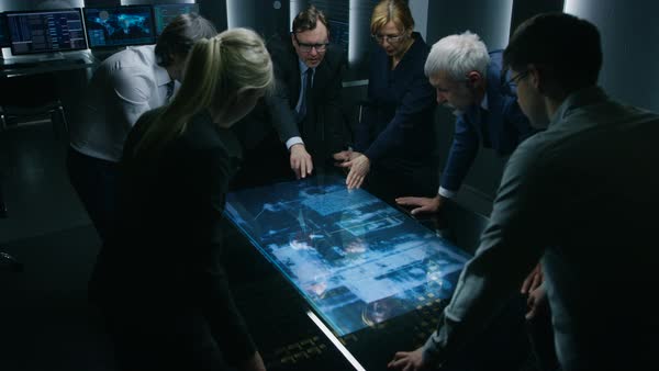 Team of government intelligence / FBI agents standing around digital ...