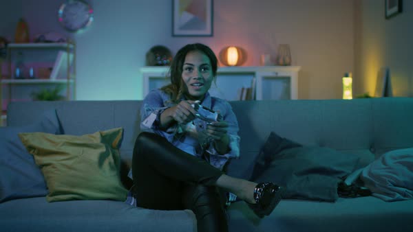 Beautiful Excited Young Black Gamer Girl Sitting on a Couch and Playing ...