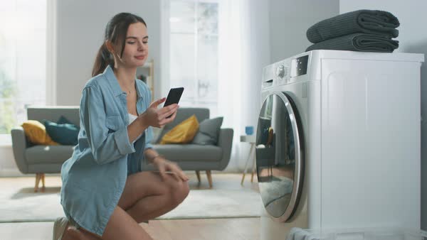 Beautiful Young Woman Sits on Her Knees Next to the Washing Machine ...