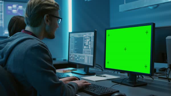 Smart male it programer working on desktop green mock-up screen ...