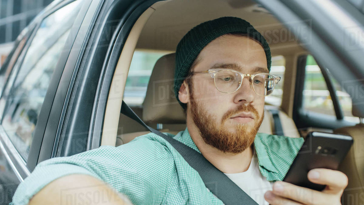 Stylish Young Man Riding in a Car, Sitting on a Passenger Seat Uses ...