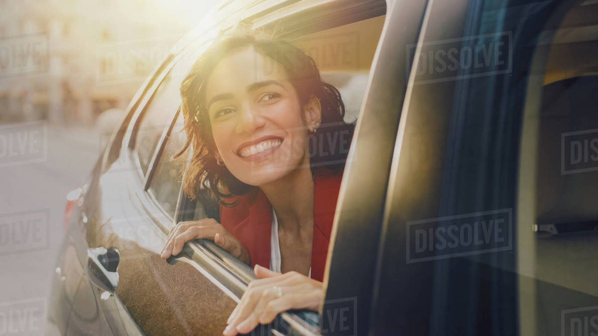 Happy Beautiful Woman Riding on a Back Seat of a Car, Looks out of the ...