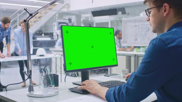 Engineer working with green screen on desktop computer with specialists ...