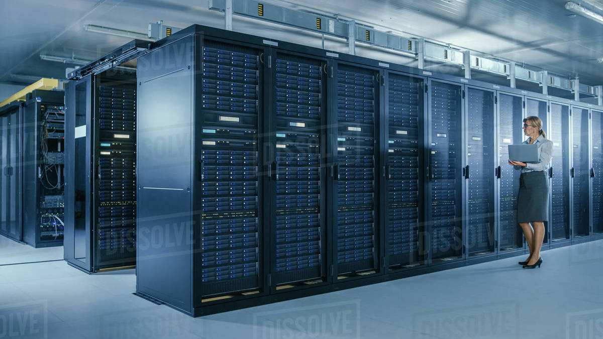 In Data Center: Female IT Specialist Walks along the Row of Operational ...