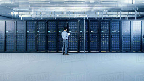 In the Modern Data Center: IT Engineer Standing Beside Open Server Rack ...
