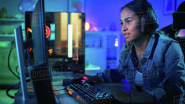 Pretty and excited black blogger girl in headphones is playing first ...