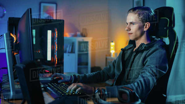 Concentrated gamer playing first-person shooter online video game on ...