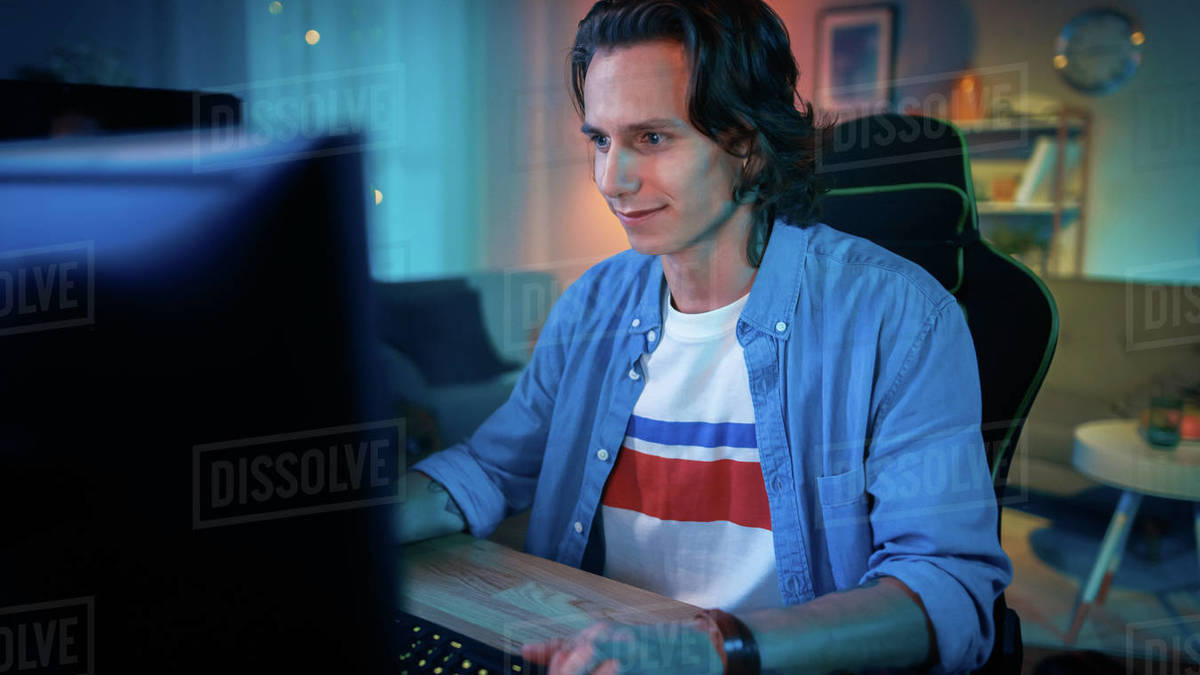 Excited gamer playing online video game on his personal computer. Room ...