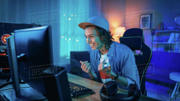 Handsome surprised and excited young man watching an action video on a ...