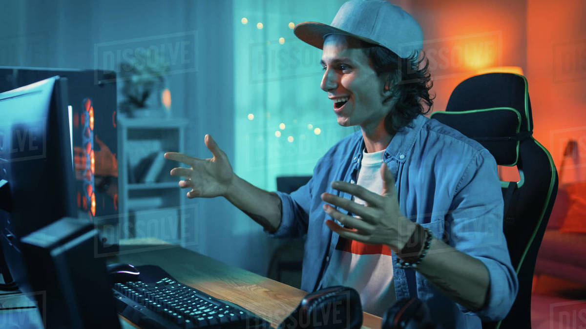 Handsome surprised and excited young man watching an action video on a ...