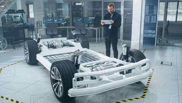 Engineer with Glasses and Beard Scans Electric Car Chassis Prototype ...