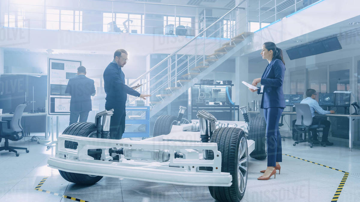 Automotive Design Engineers Looking at Technical Drawings of a Electric ...