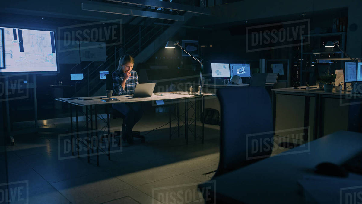 Beautiful Female Engineer Sitting at Her Desk Works on a Laptop ...