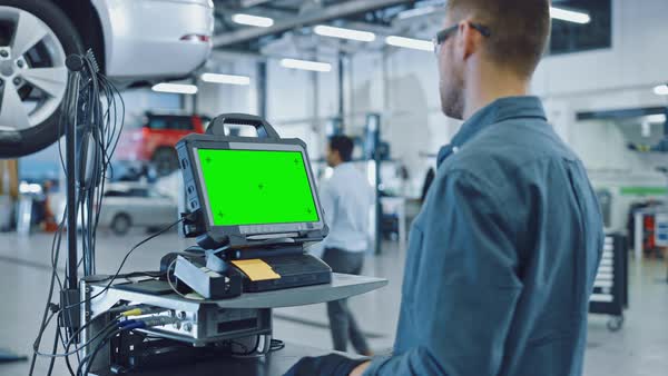 Car Service Mechanic is Running a Diagnostics Software on an Advanced ...