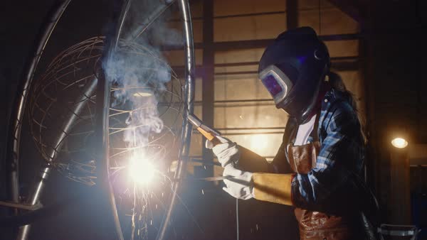 Beautiful Female Artist is Welding a Brutal Metal Sculpture in a Dark ...