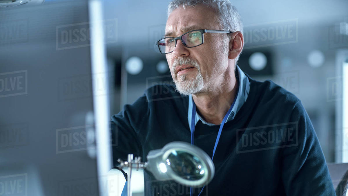 Middle Aged Electronics Repair Engineer Working on Personal Computer in ...