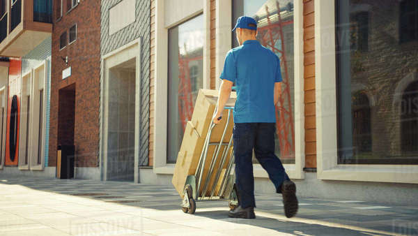 Delivery Man Pushes Hand Truck Trolley Full of Cardboard Boxes ...