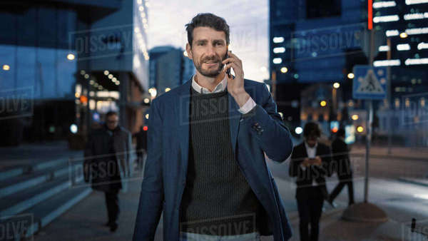 Tall Businessman in a Suit is Talking on a Phone While Walking in the ...