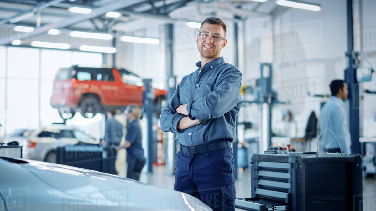 Handsome Car Mechanic is Posing in a Car Service. He Wears a Jeans ...