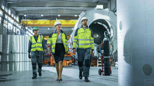 Team of Heavy Industry Engineers and Workers Walking through Pipe ...