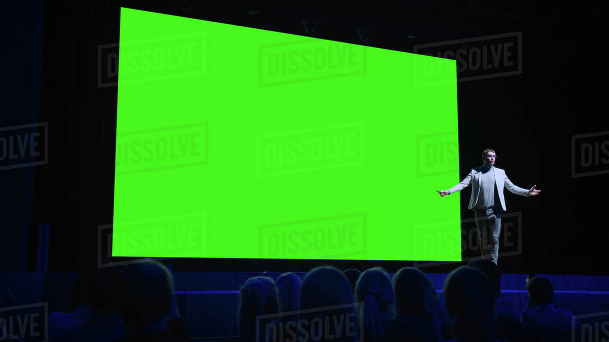 Keynote Speaker Announces New Product to the Audience, Behind Him Movie ...