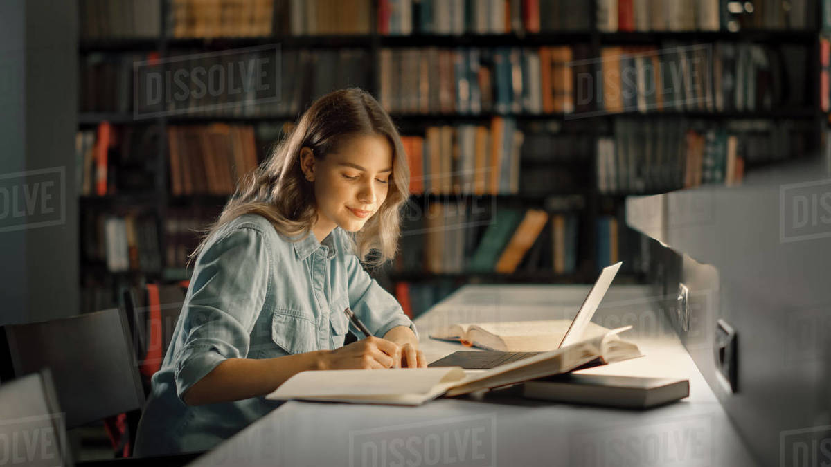 University Library: Beautiful Smart Girl uses Laptop, Writes Notes for ...