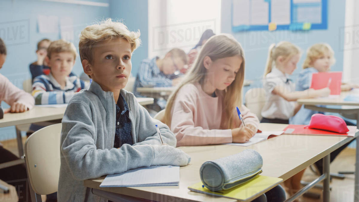 Elementary Classroom of Diverse Children Listening Attentively to their ...