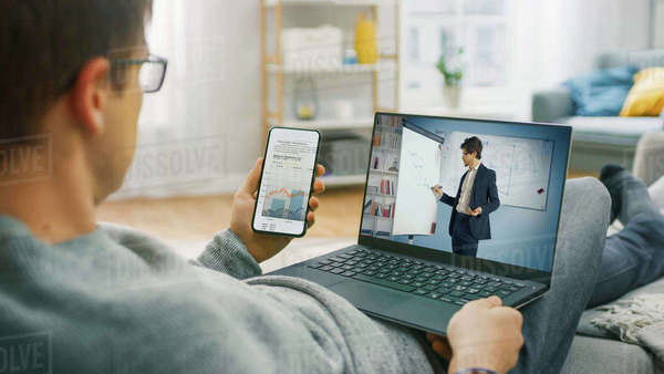 Young Man at Home Works on a Laptop Computer sing Laptop Computer for ...