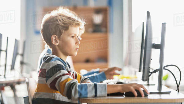 Elementary School Computer Science Classroom: Cute Little Boy Uses ...