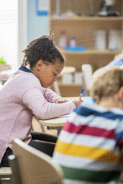 In Elementary School Classroom Brilliant Black Girl Writes in Exercise ...