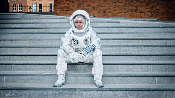 Sad Man in Spacesuit is Sitting on Concrete Stairs. Astronaut is ...