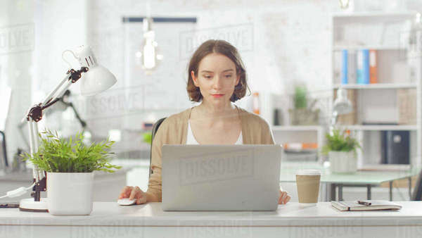 Portrait Shot of a Young Creative Woman Sitting at Her Desk and Using ...