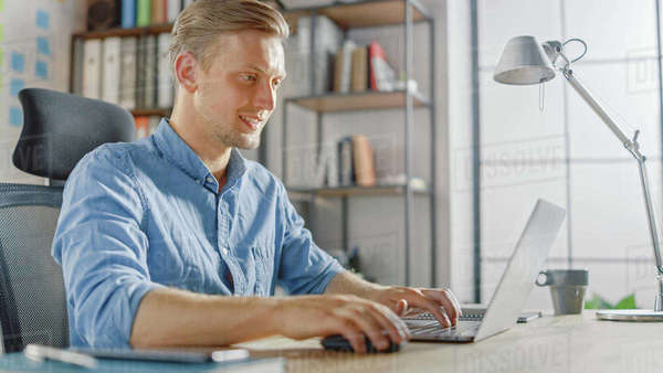 Handsome Blonde Businessman Sitting at His Desk in the Office Works on ...