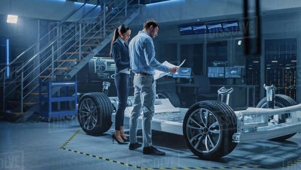 Auto Industry Design Facility: Male Chief Engineer Shows Car Blueprints ...