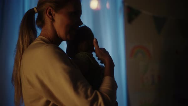 Caring mom hugging their cute baby, bonding before going to sleep ...