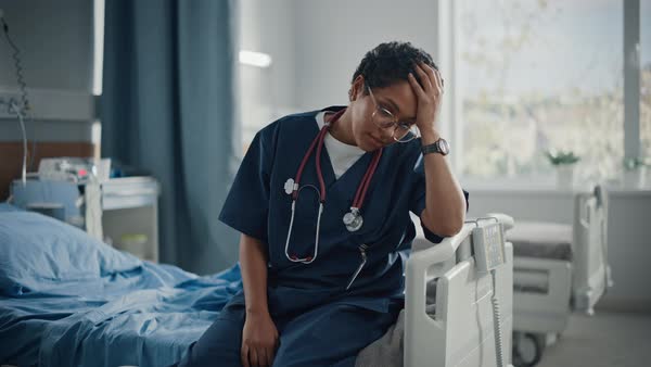 Hospital Ward: Portrait of Sad, Tired Black Nurse Sitting on a Bed ...