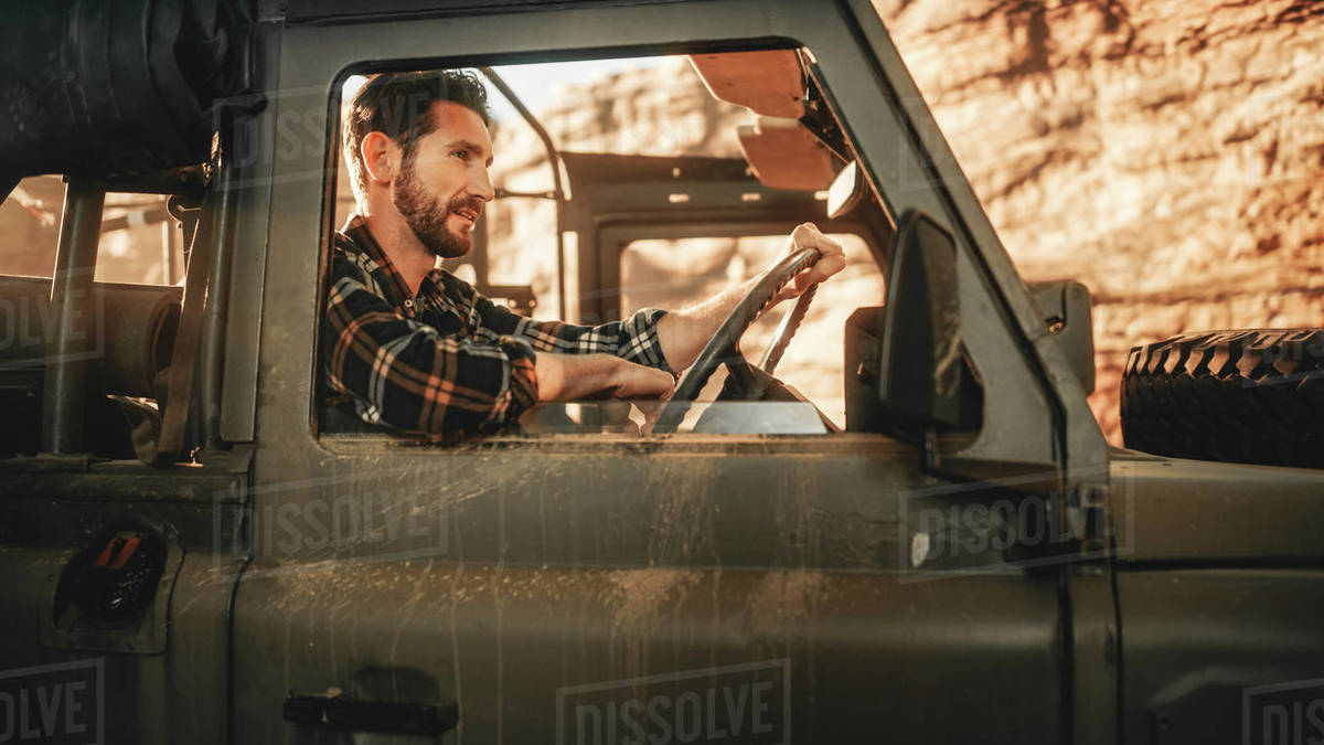 Desert Road Trip: Portrait of Handsome Male Explorer Looking out of Car ...