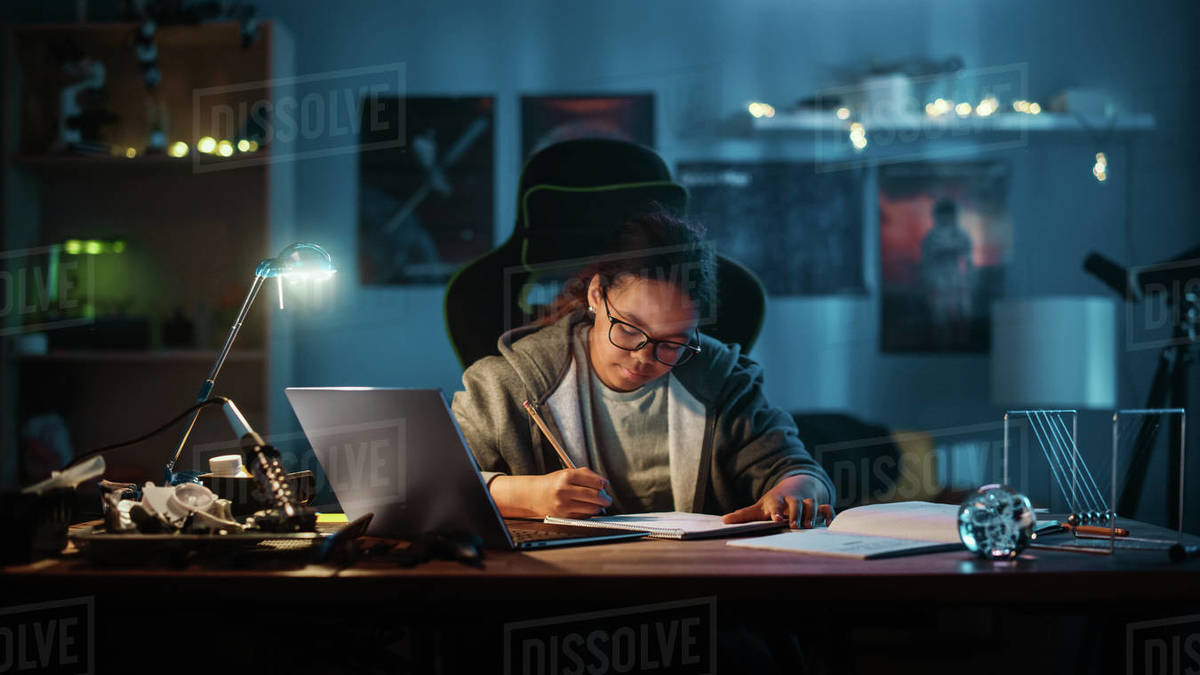 Young Teenage Black Girl Writing Down Homework in a Notebook with a ...