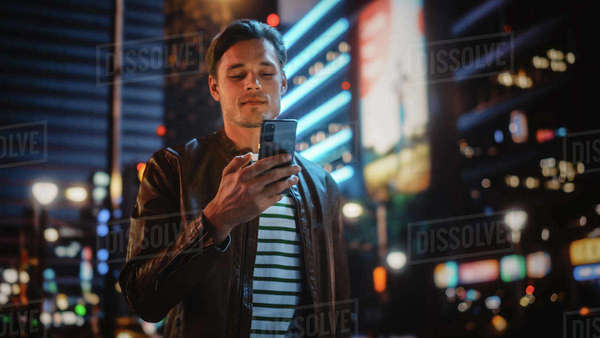 Man Using Smartphone Walking Through Night City Street Full of Neon ...