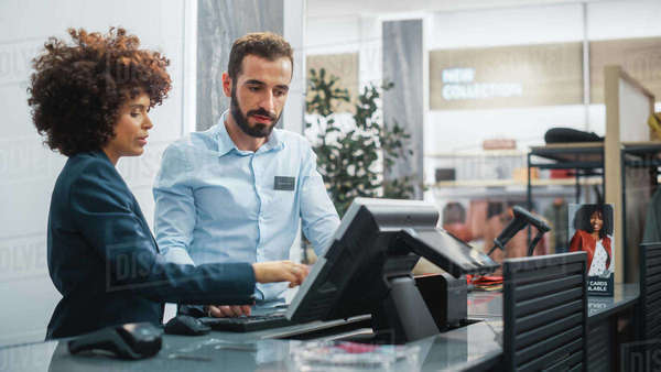 Female Retail Sales Manager Explaining to New Male Assistant Employee ...